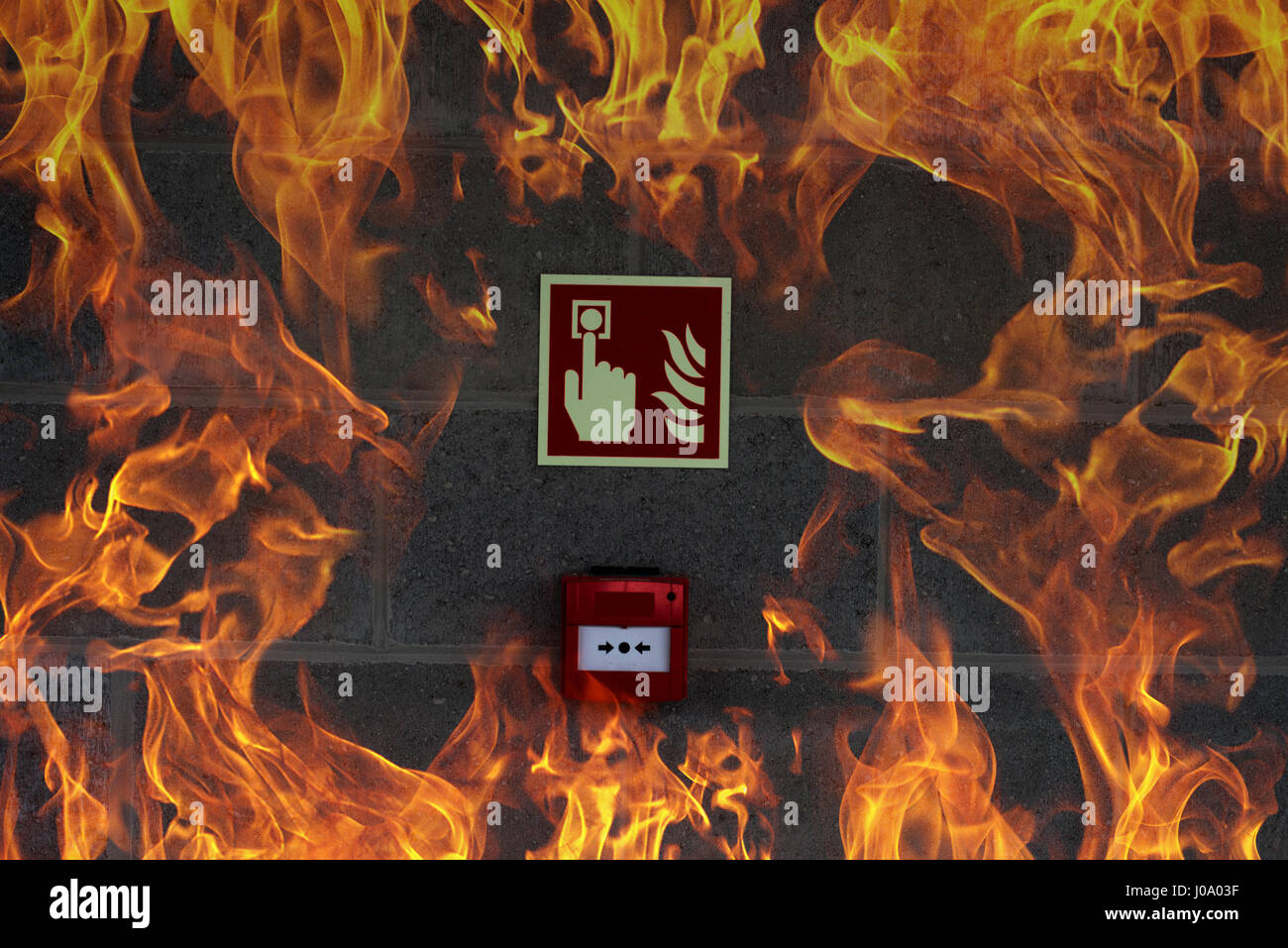 Emergency Fire Exit on the stone wall with fire flames Stock Photo - Alamy