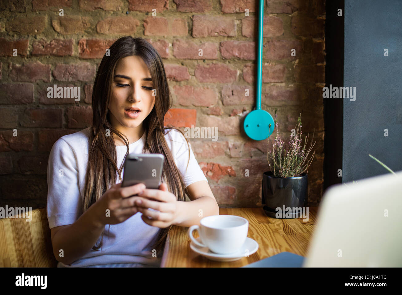 Woman typing write message on smart phone in a modern cafe. Young ...