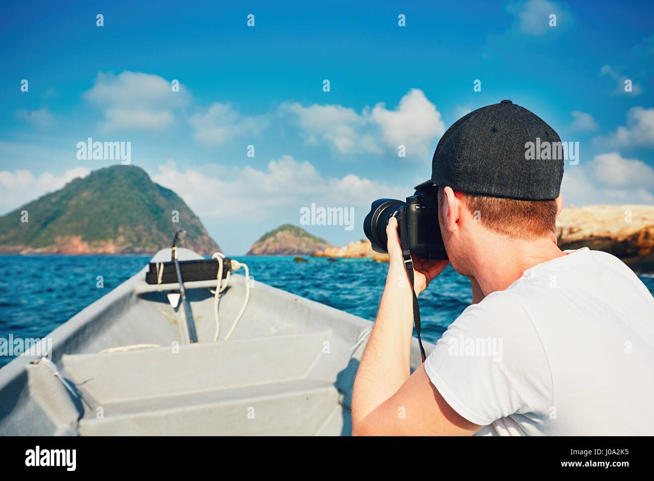 Young photographer with dslr camera shooting on the boat Stock Photo ...