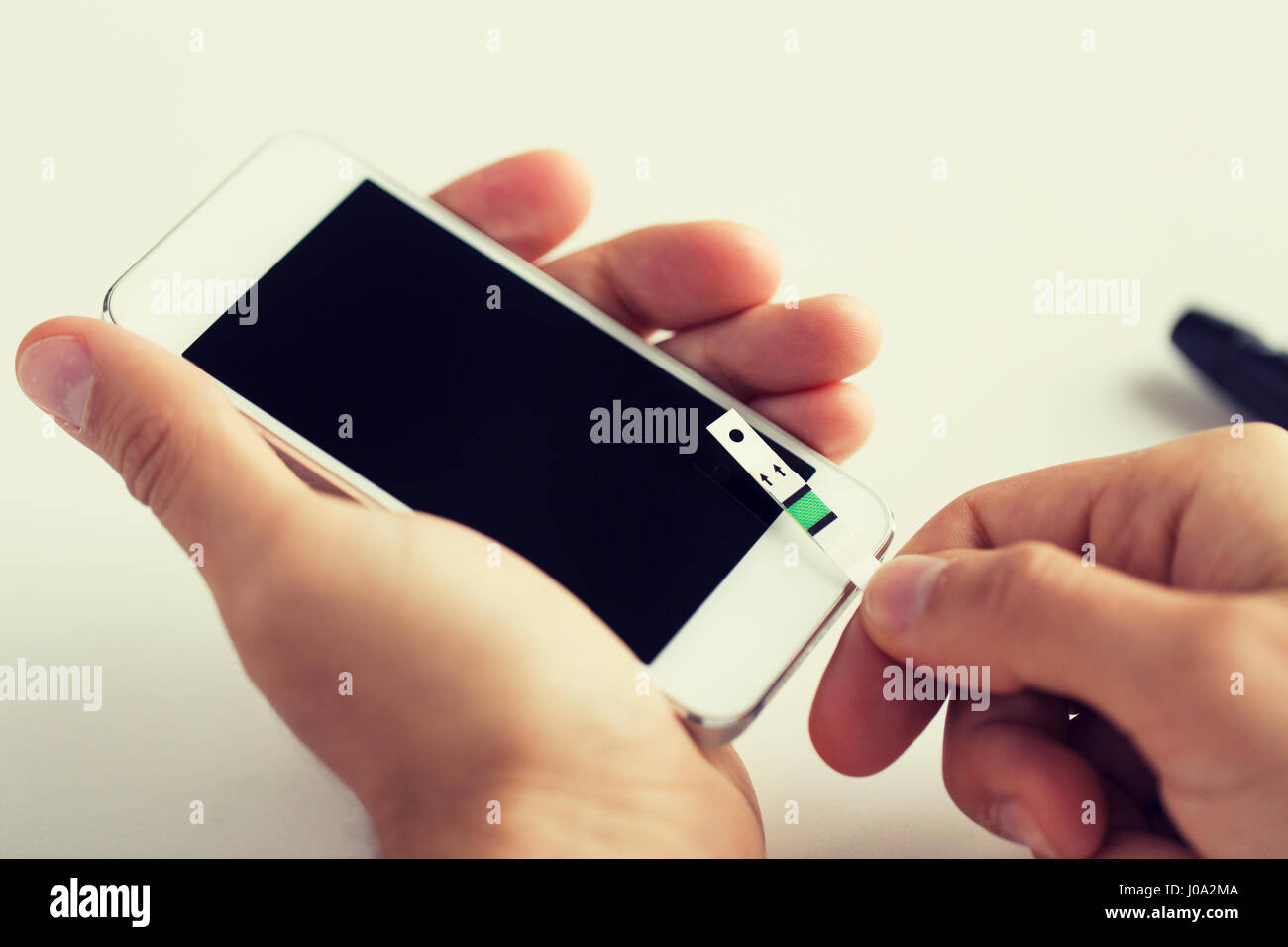 close up of man with smartphone making blood test Stock Photo - Alamy