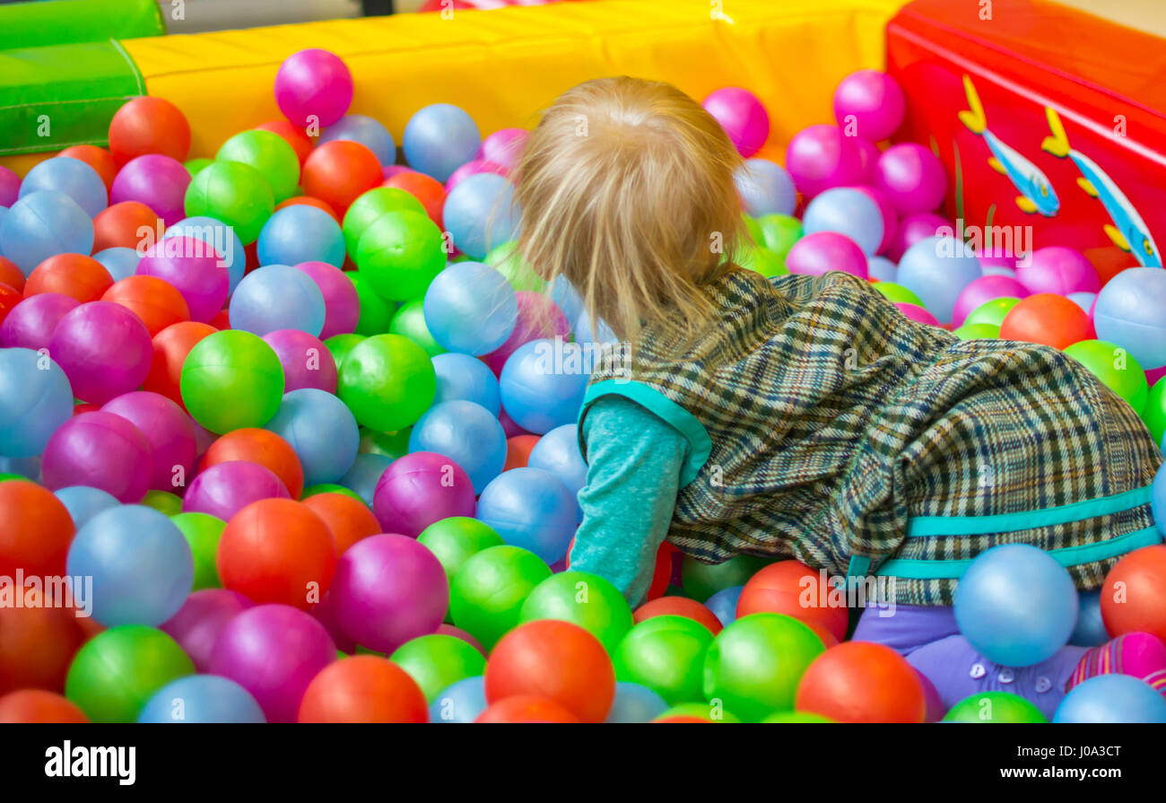 a small child in the pool with balls Stock Photo - Alamy