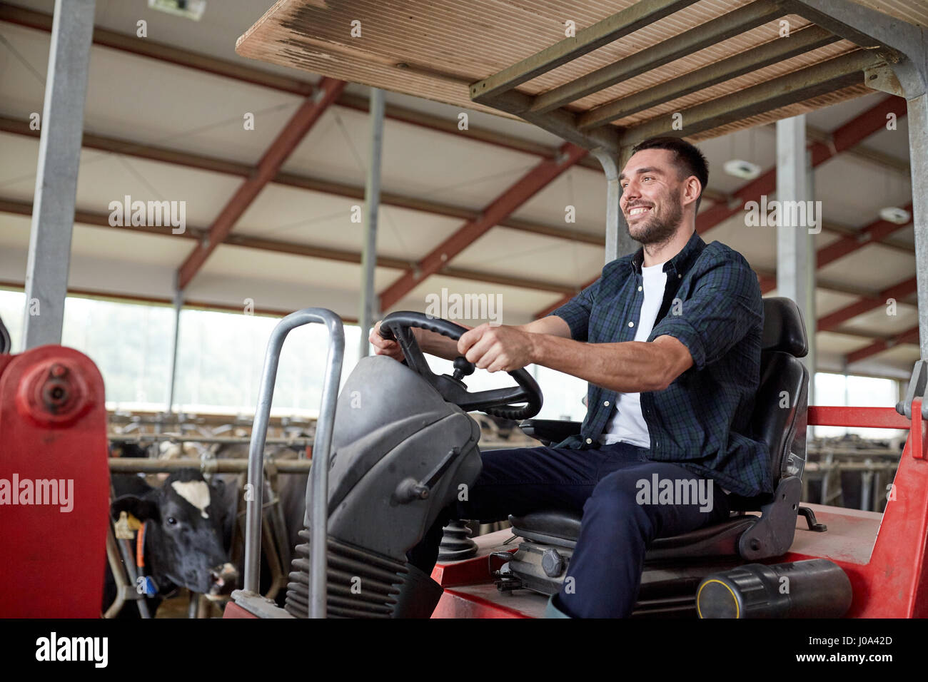 man or farmer driving tractor at farm Stock Photo - Alamy