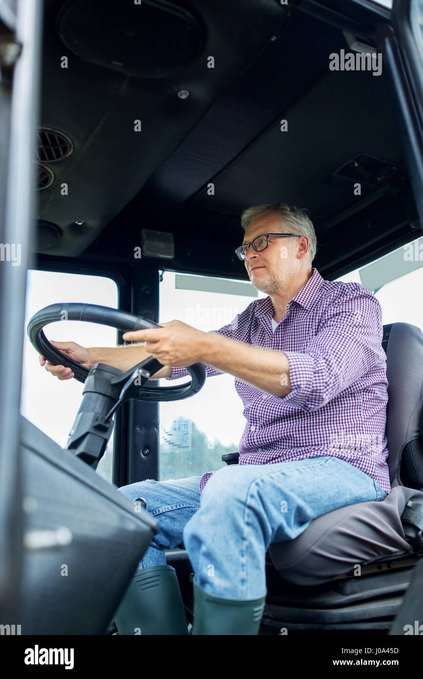 senior man driving tractor at farm Stock Photo - Alamy