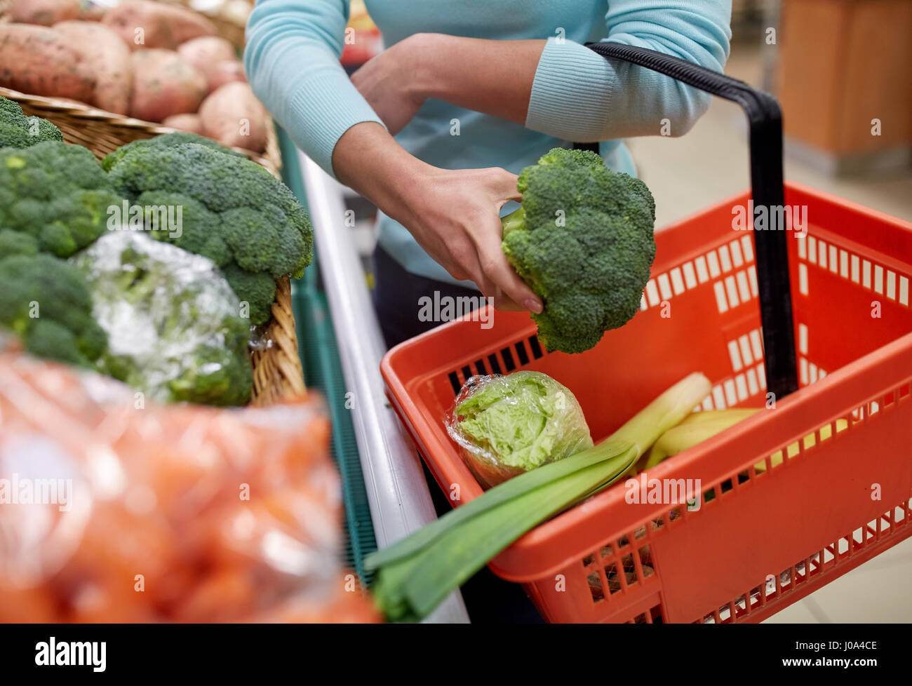 woman with basket buying broccoli at grocery store Stock Photo - Alamy