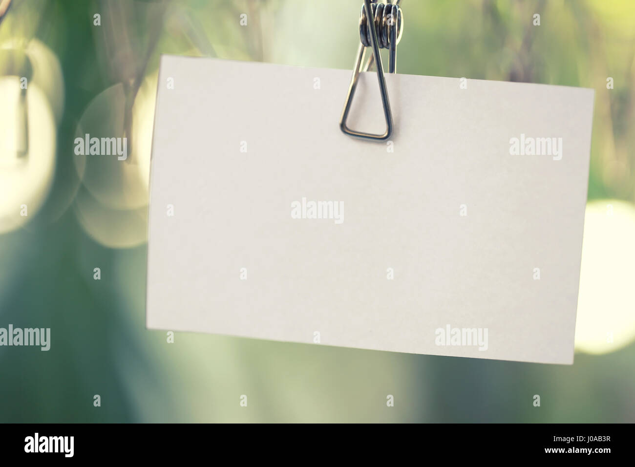 white paper notes hanging in a clothesline on green bokeh background ...