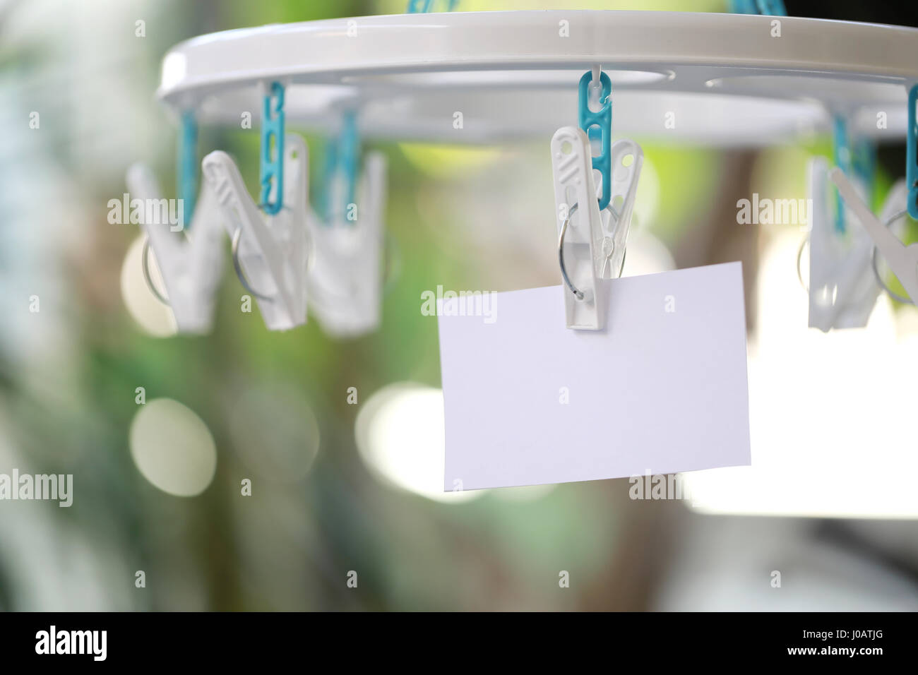 white paper notes hanging in a clothesline on green bokeh background ...