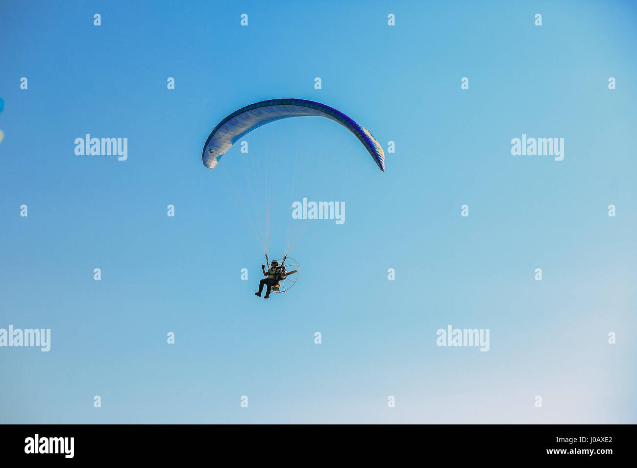 Paragliding flight with blue sky and some clouds Stock Photo - Alamy