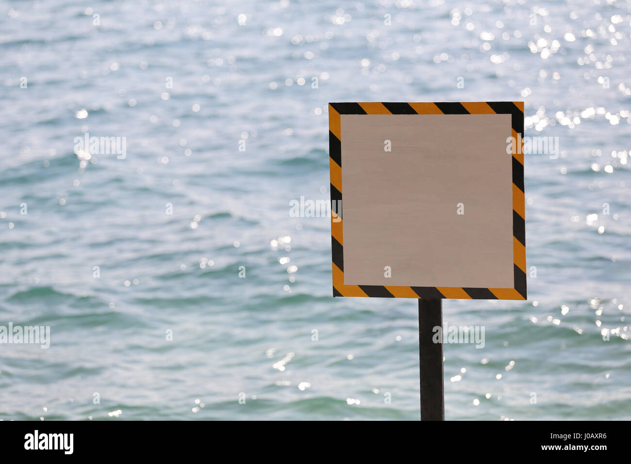 Warning labels in seaside and have sea background Stock Photo - Alamy