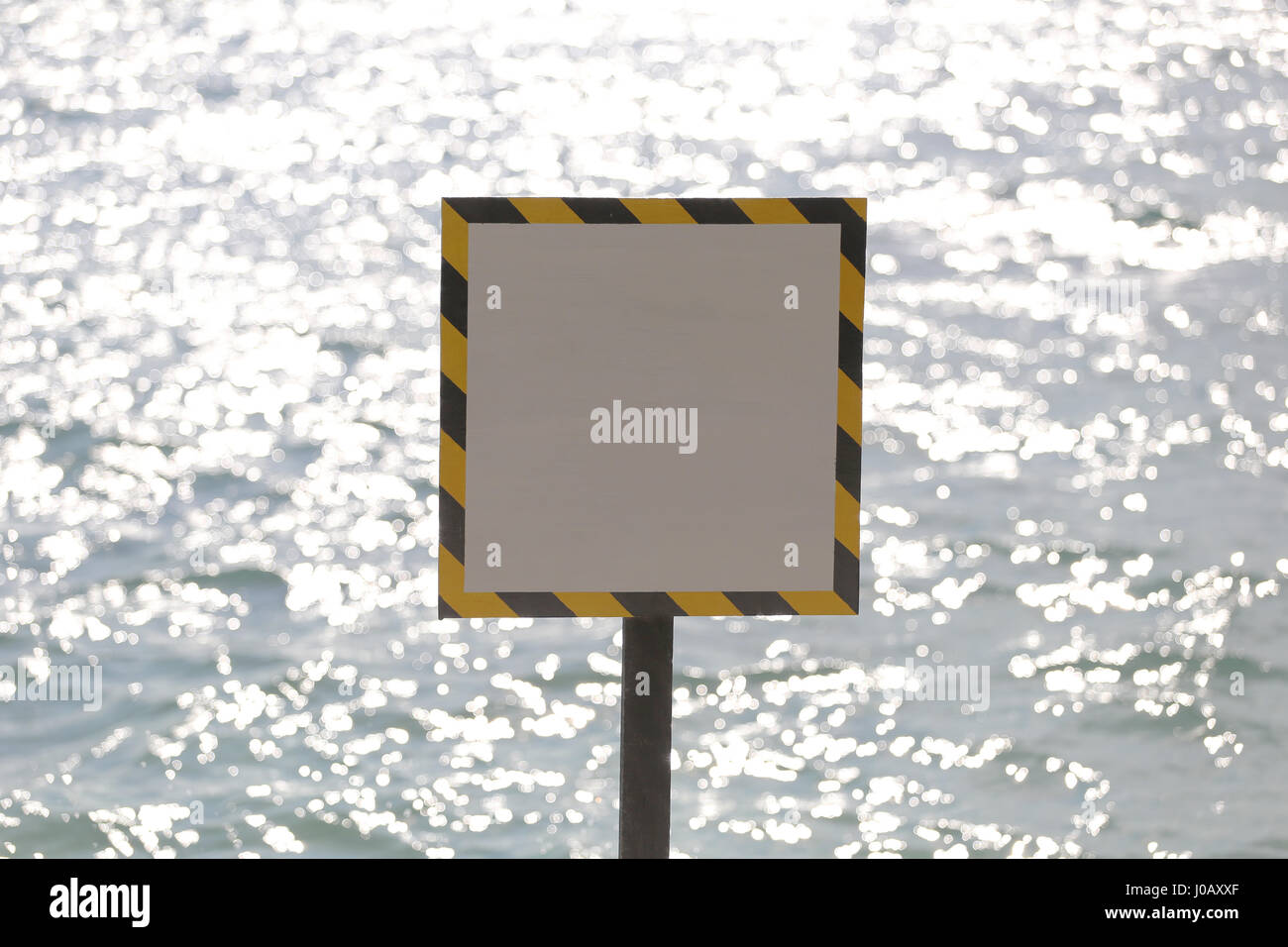 Warning labels in seaside and have sea background Stock Photo - Alamy