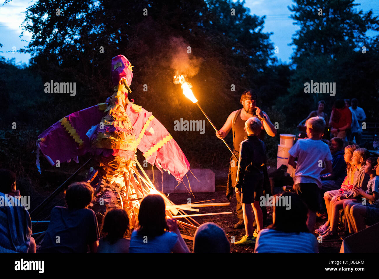 Man with flaming torch lighting a Phoenix on a camp bonfire Stock Photo ...