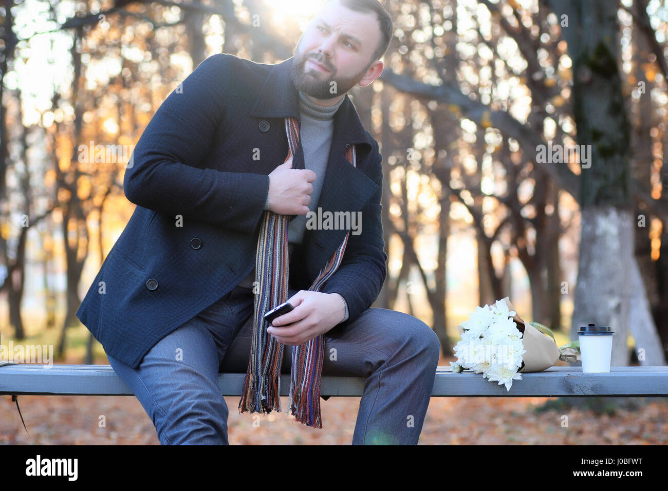 man waiting on a bench the date in autumn park Stock Photo - Alamy