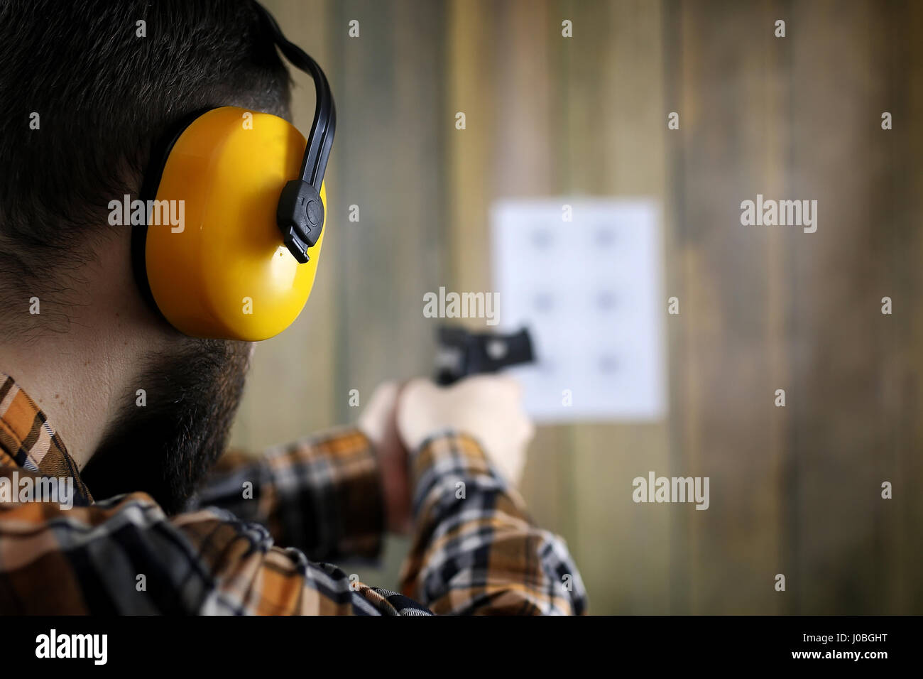 man with put on protective goggles and ear training in pistol sh Stock ...