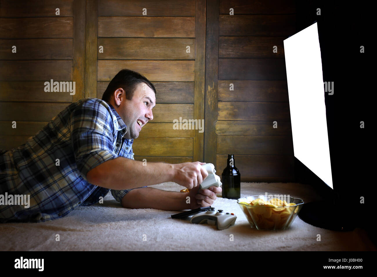man playing on a console on the joystick before the big TV Stock Photo ...