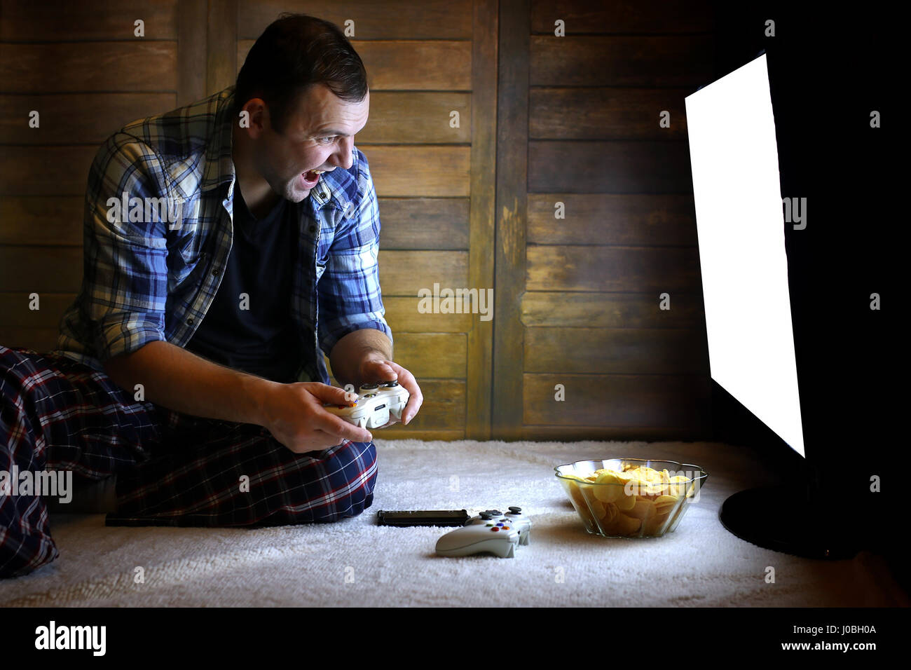 man playing on a console on the joystick before the big TV Stock Photo ...