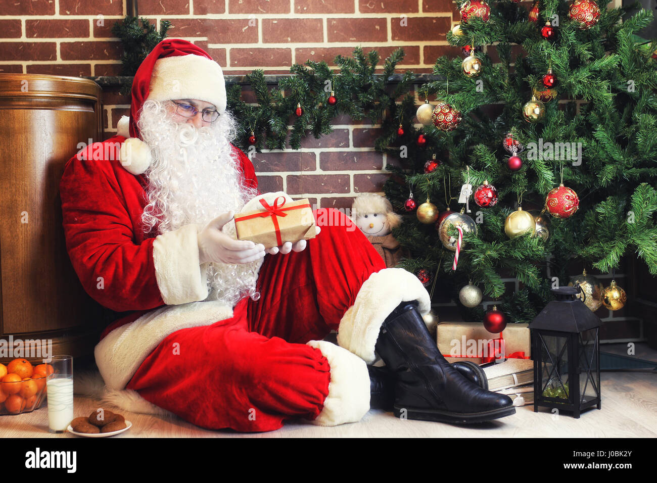 Santa Claus in a red suit and white beard at the Christmas tree Stock ...