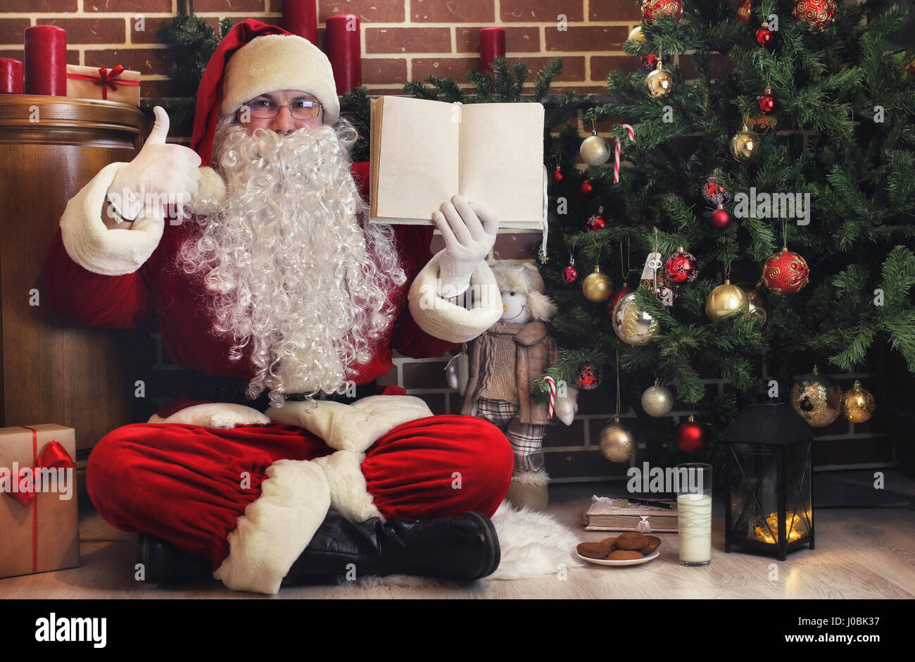 Santa Claus in a red suit and white beard at the Christmas tree Stock ...