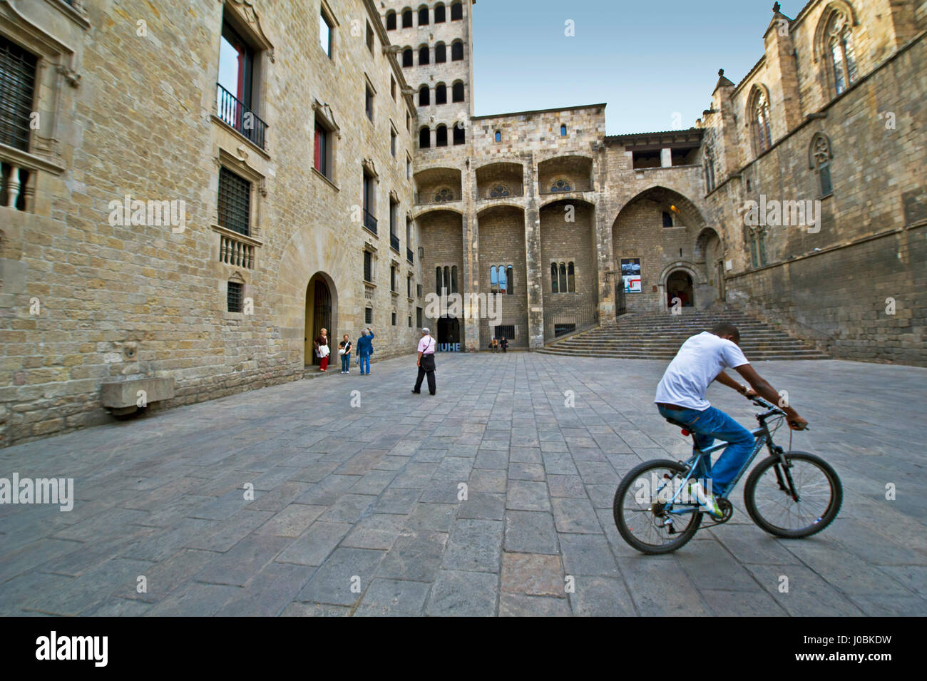 Young man riding a bicycle in medieval part of Barcelona Stock Photo ...