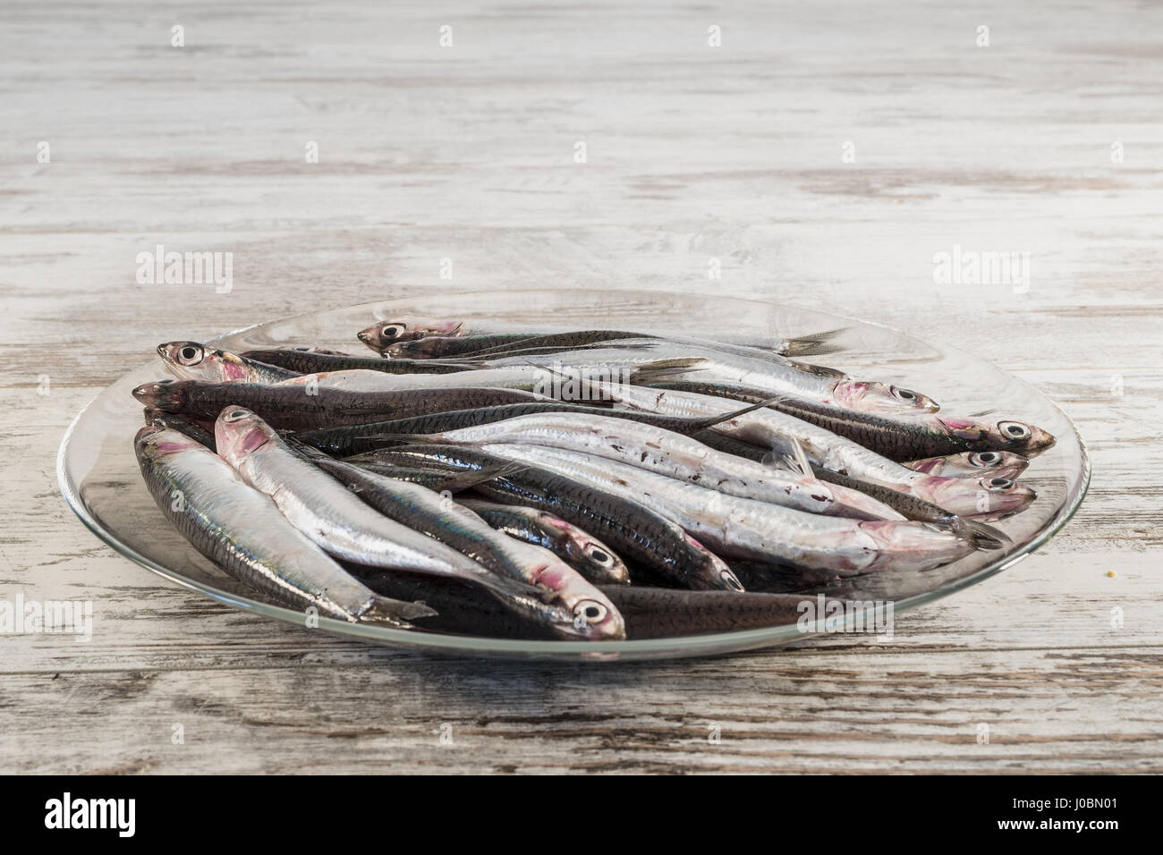 fresh anchovies in glass dish from the bottom face Stock Photo - Alamy