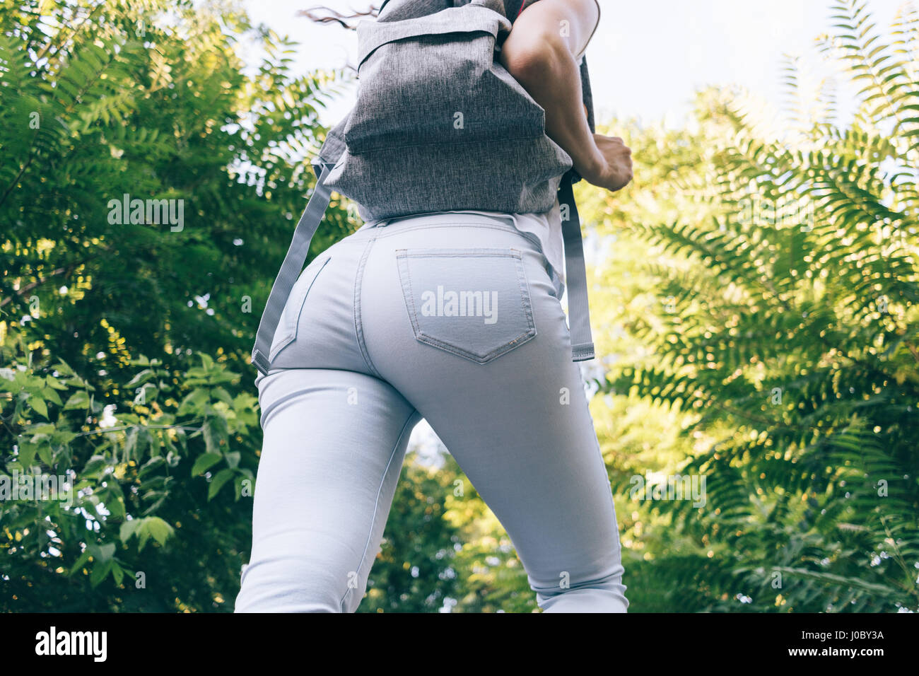 Bottom view of a tourist in jeans with a backpack walking among the ...