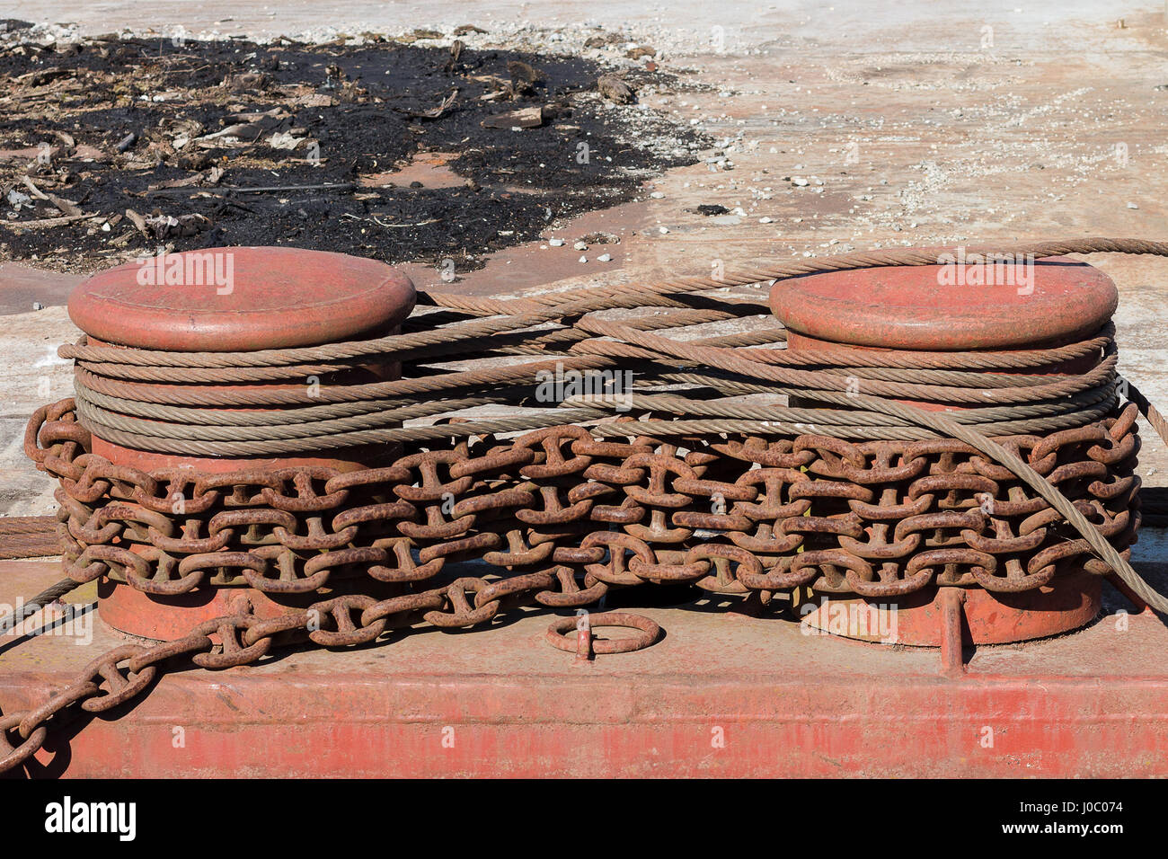 Two metal bollards with rusty chains and cables Stock Photo - Alamy