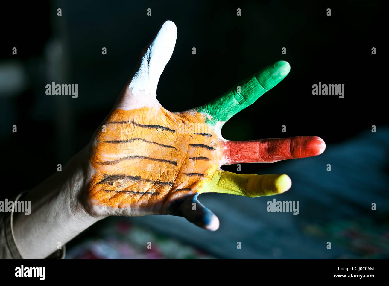 Tiger colored aggressive human painted hand with black strokes on it ...