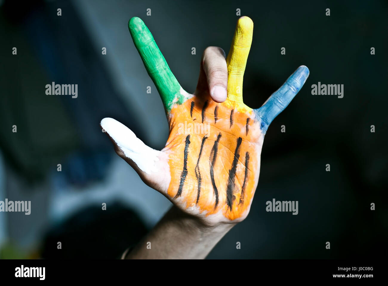 Tiger colored aggressive human painted hand with black strokes on it ...