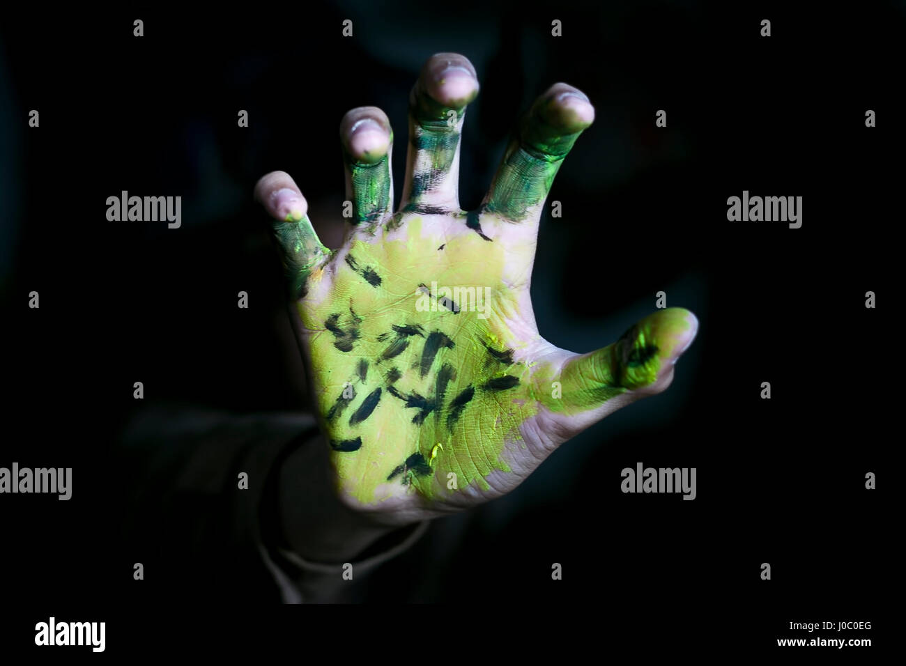 leopard color painted human hand with black strokes and green finger ...