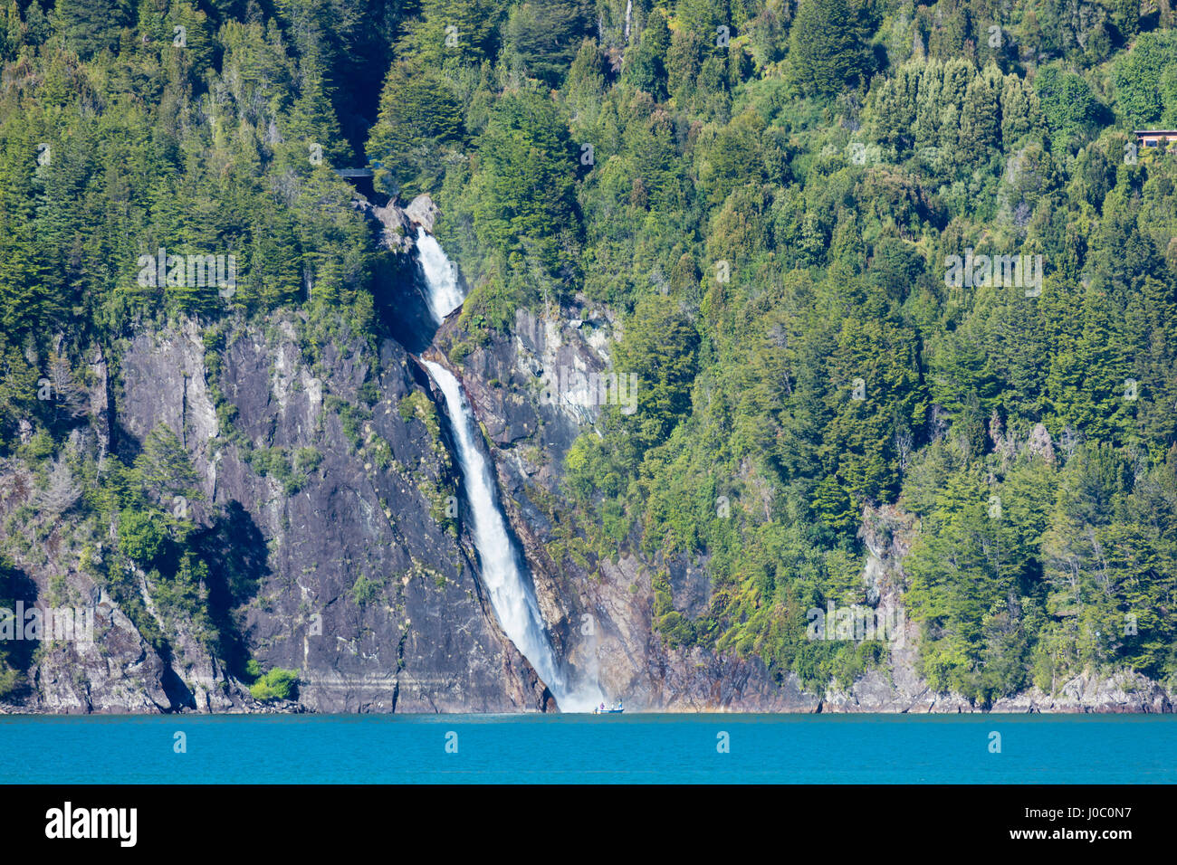 A boat in front of a waterfall on Puelo Lake in the Tagua Tagua reserve ...