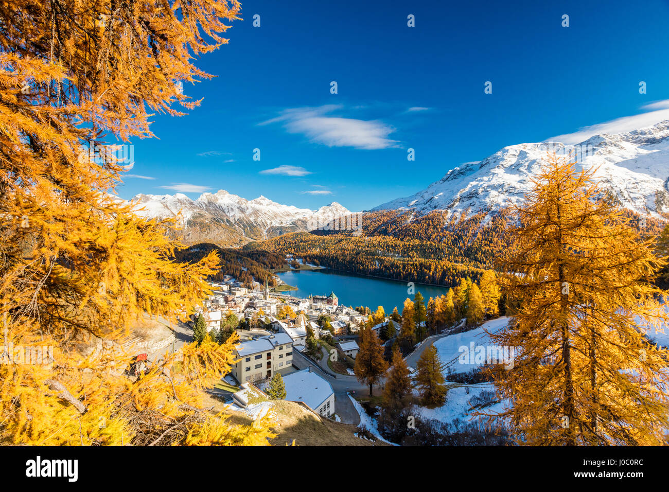 The alpine village of St. Moritz framed by colorful woods and the blue ...