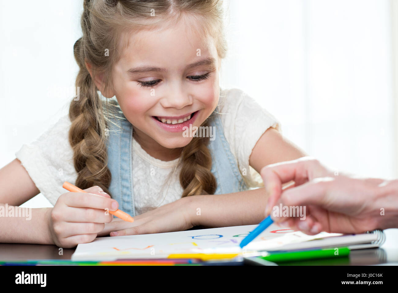 Happy mother and daughter drawing at home Stock Photo - Alamy