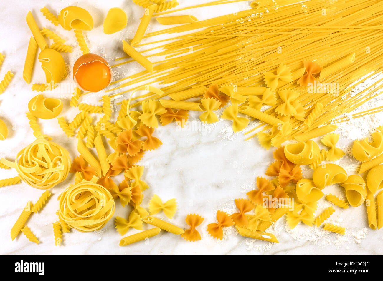 Various types of pasta with egg on marble with copyspace Stock Photo ...