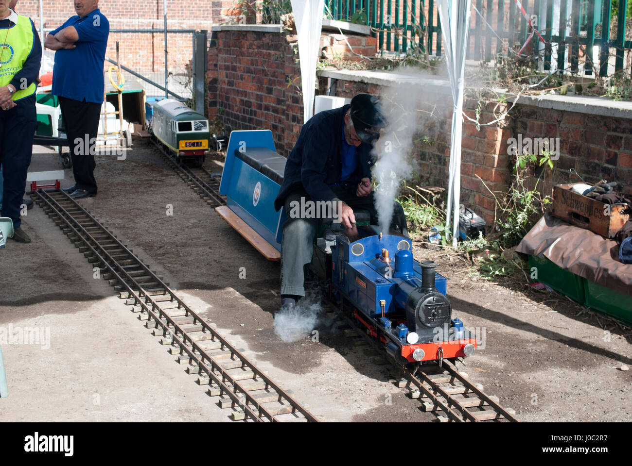 Man sitting on model steam train Stock Photo - Alamy