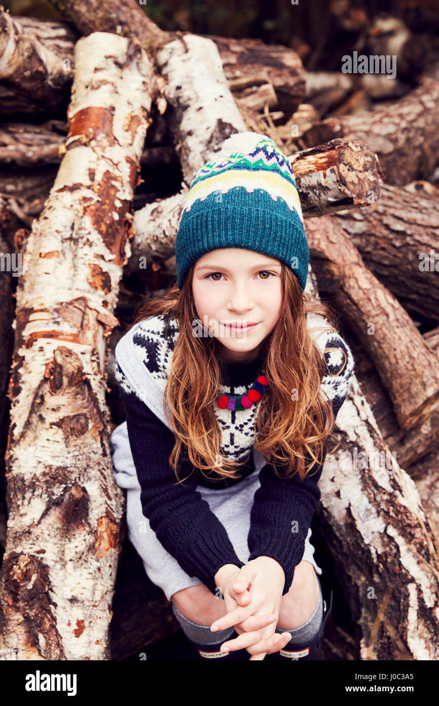 Girl sitting on log pile hi-res stock photography and images - Alamy