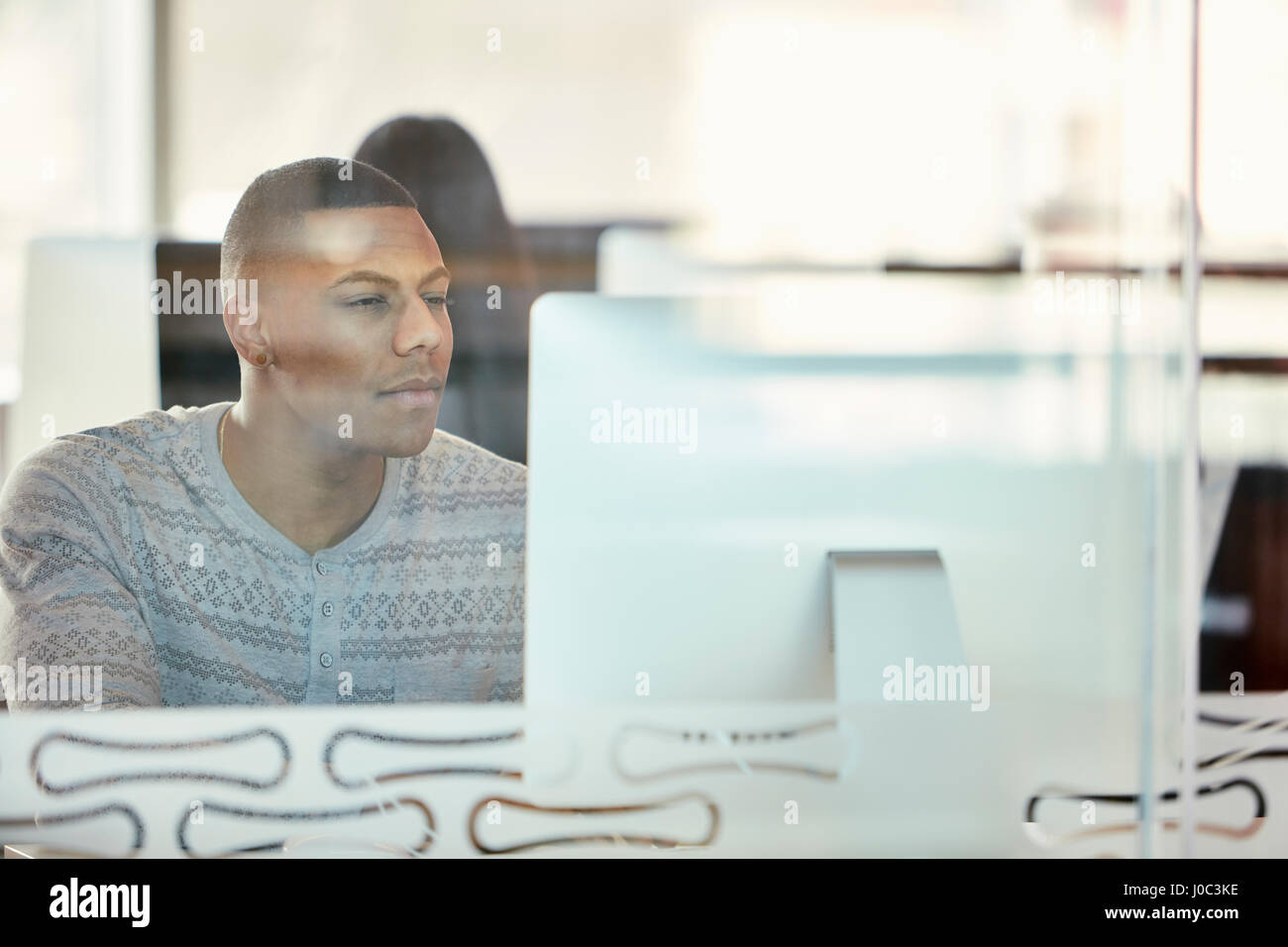 University student working at computer behind glass partition Stock ...
