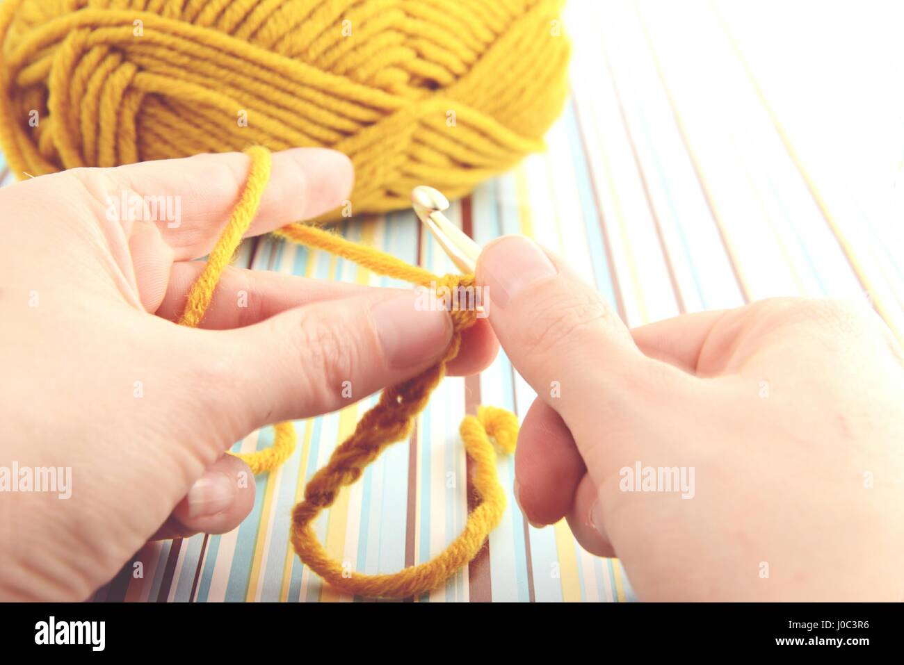 crocheting with wool ball and crocheting hook Stock Photo - Alamy