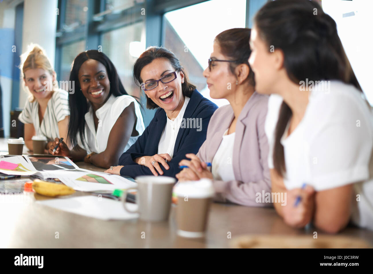 Female colleagues discussing having coffee hi-res stock photography and ...