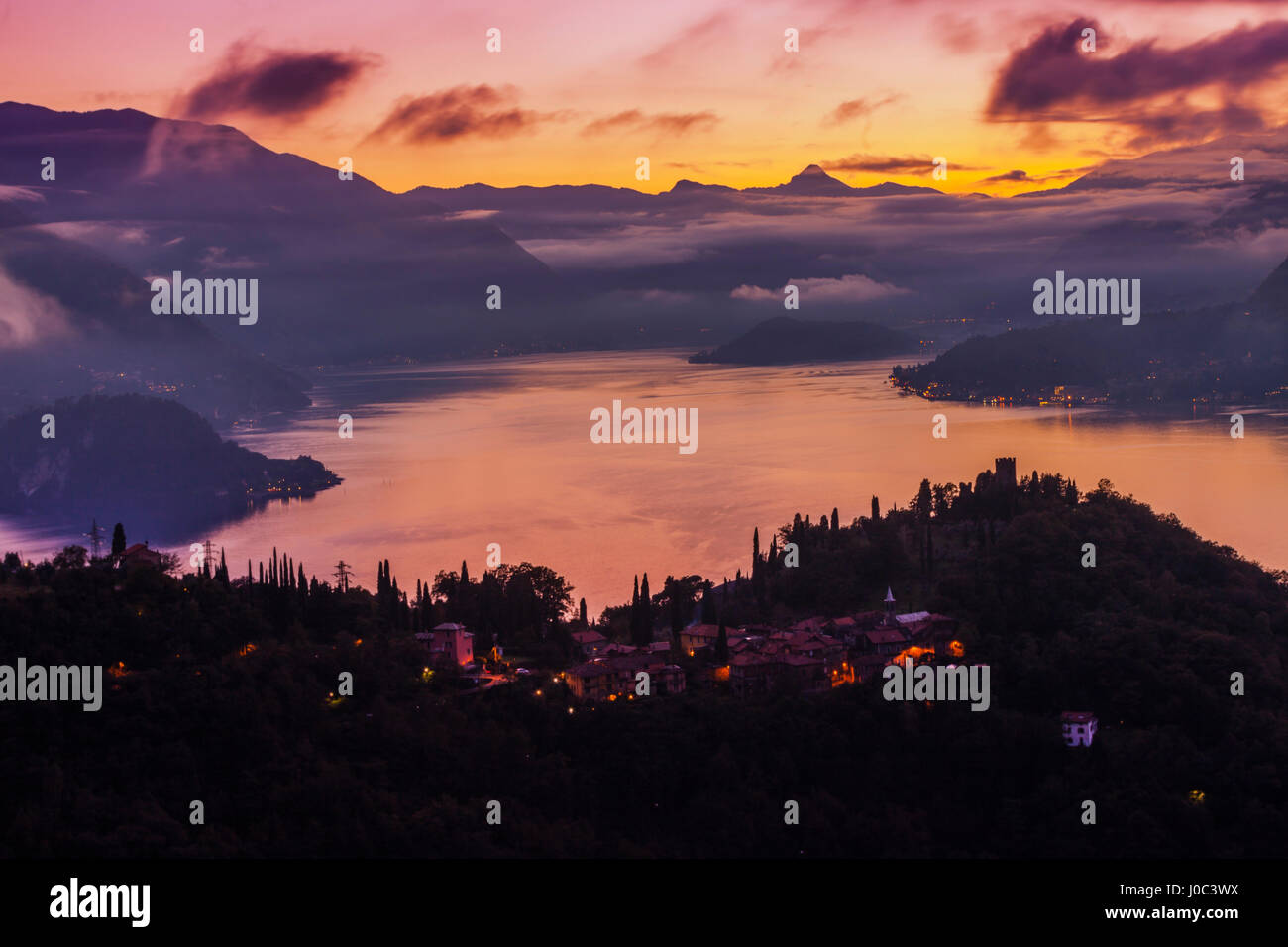 Cloud covered mountains across Lake Como at sunset, Varenna, Italy ...