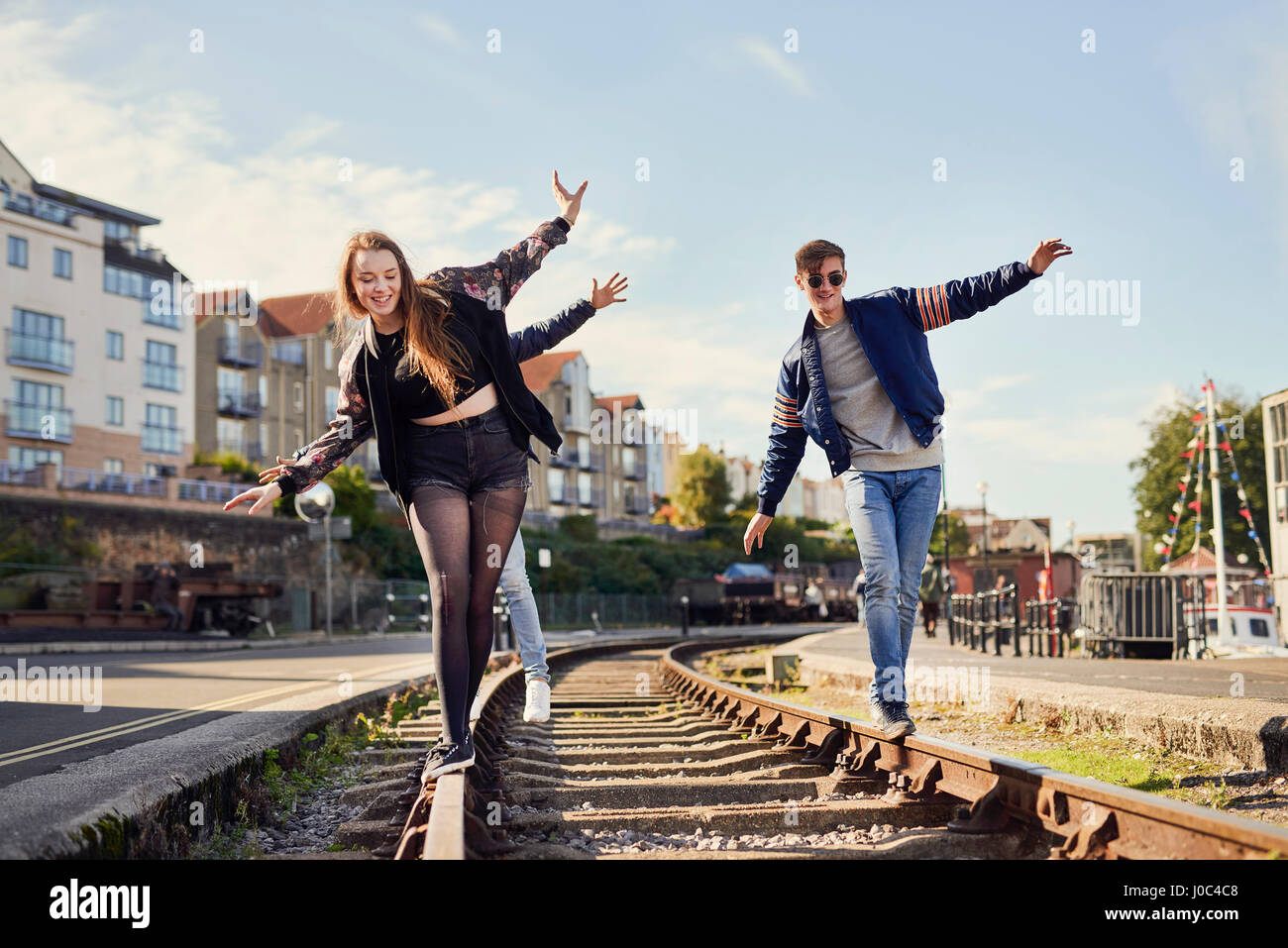 Three friends balancing on train track, Bristol, UK Stock Photo - Alamy