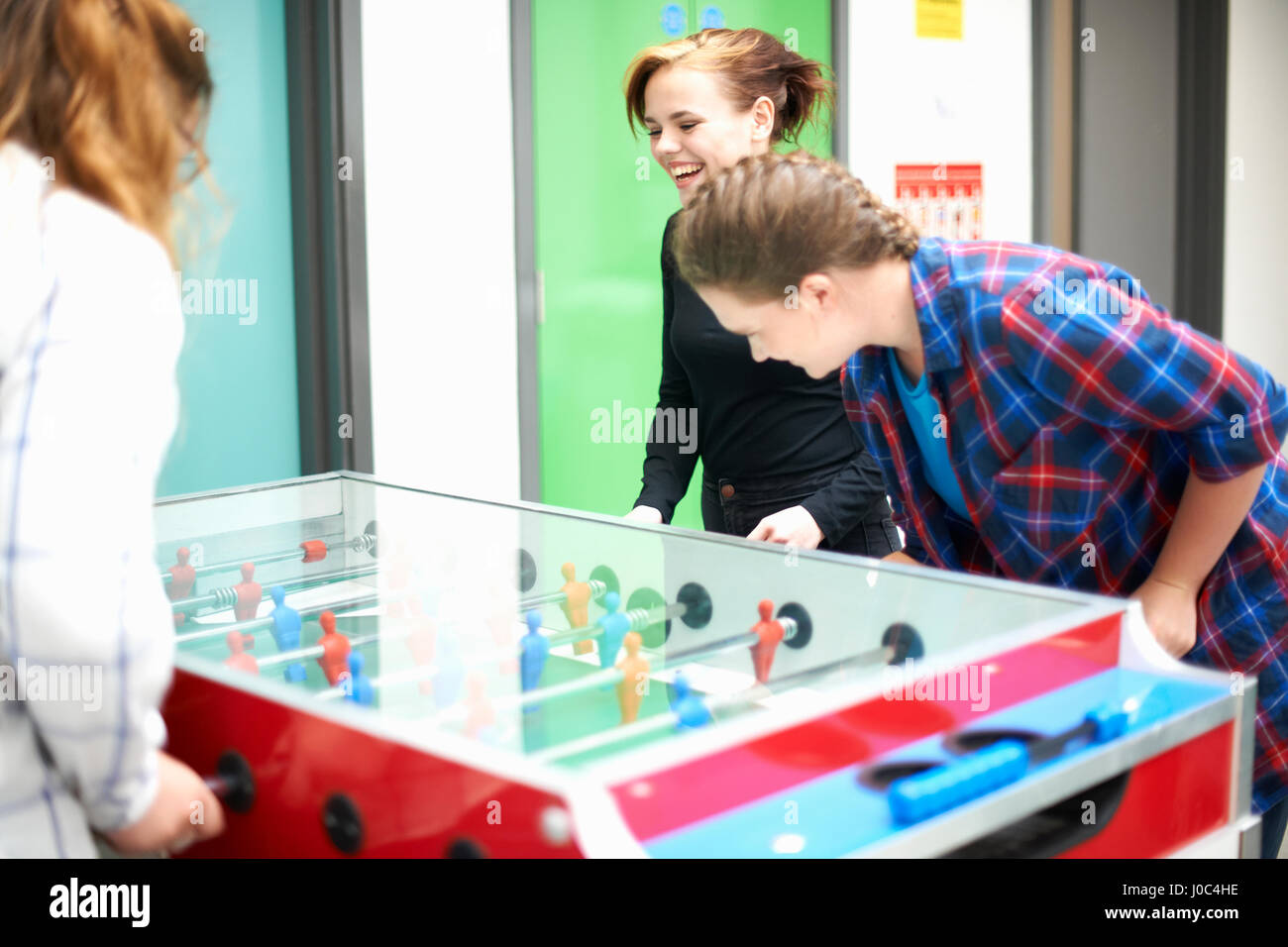 Group of female friends playing table football Stock Photo - Alamy