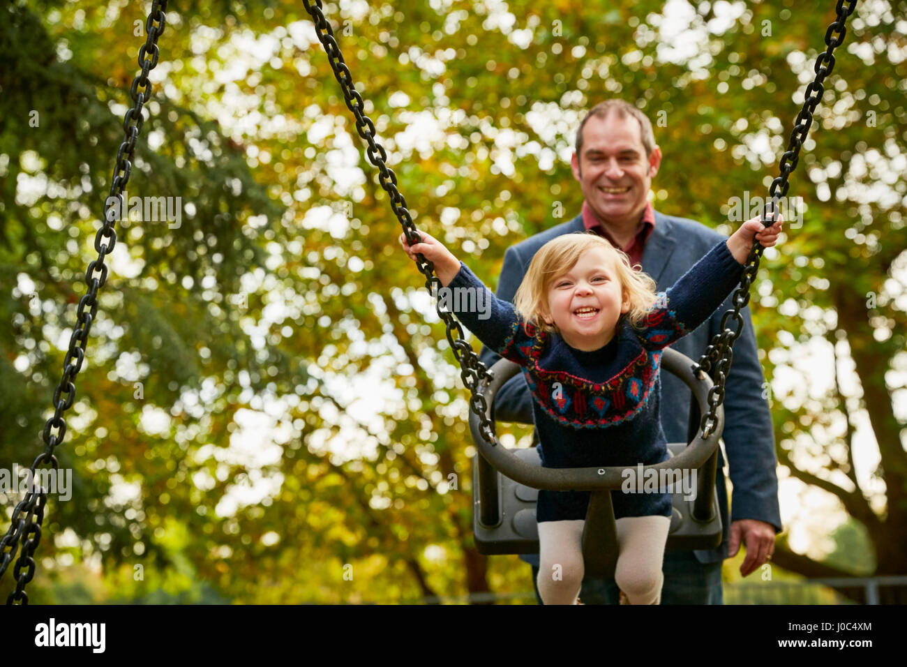 Parent pushing child swing hi-res stock photography and images - Alamy