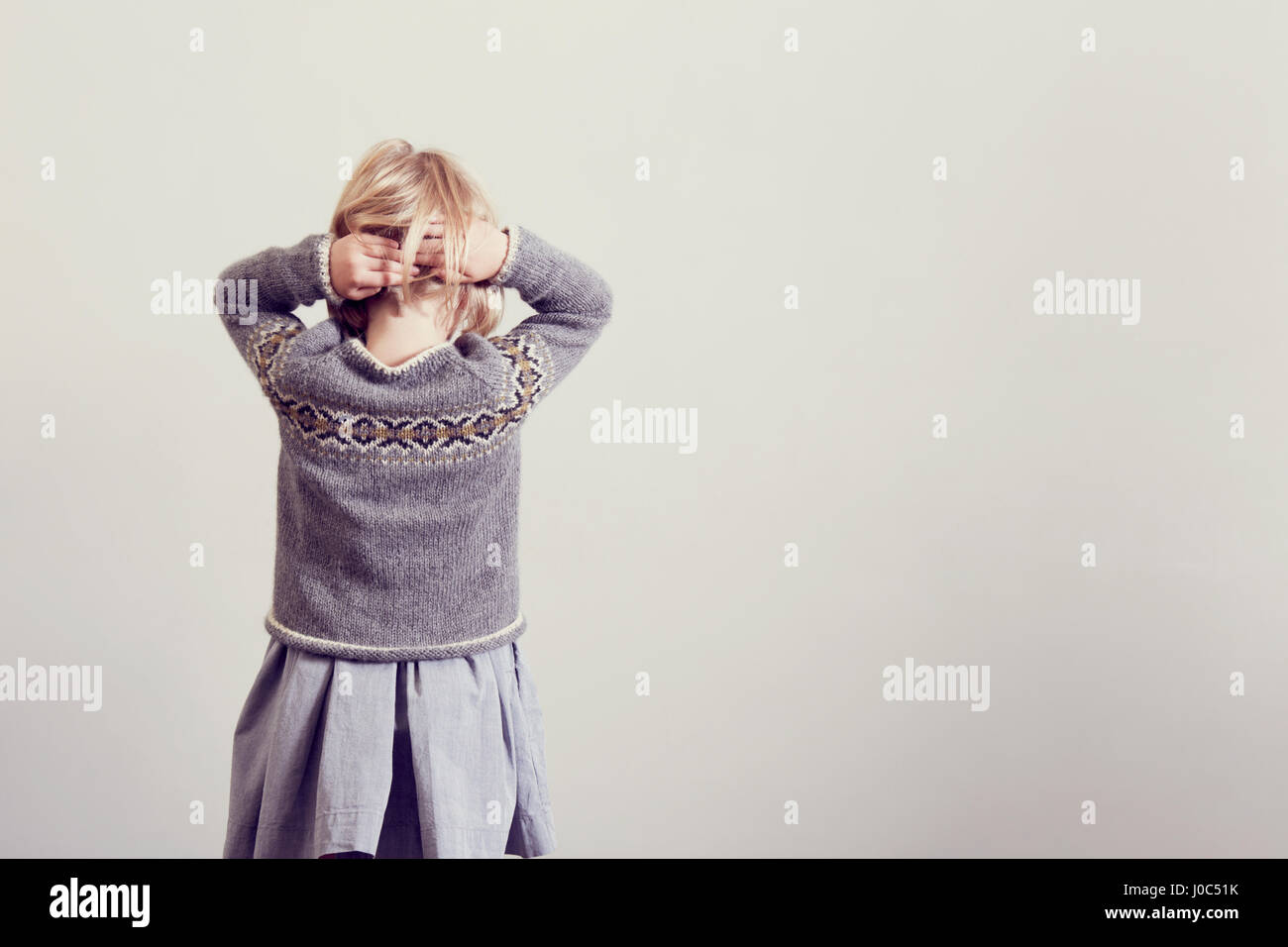Rear view of girl fidgeting with blond hair Stock Photo - Alamy