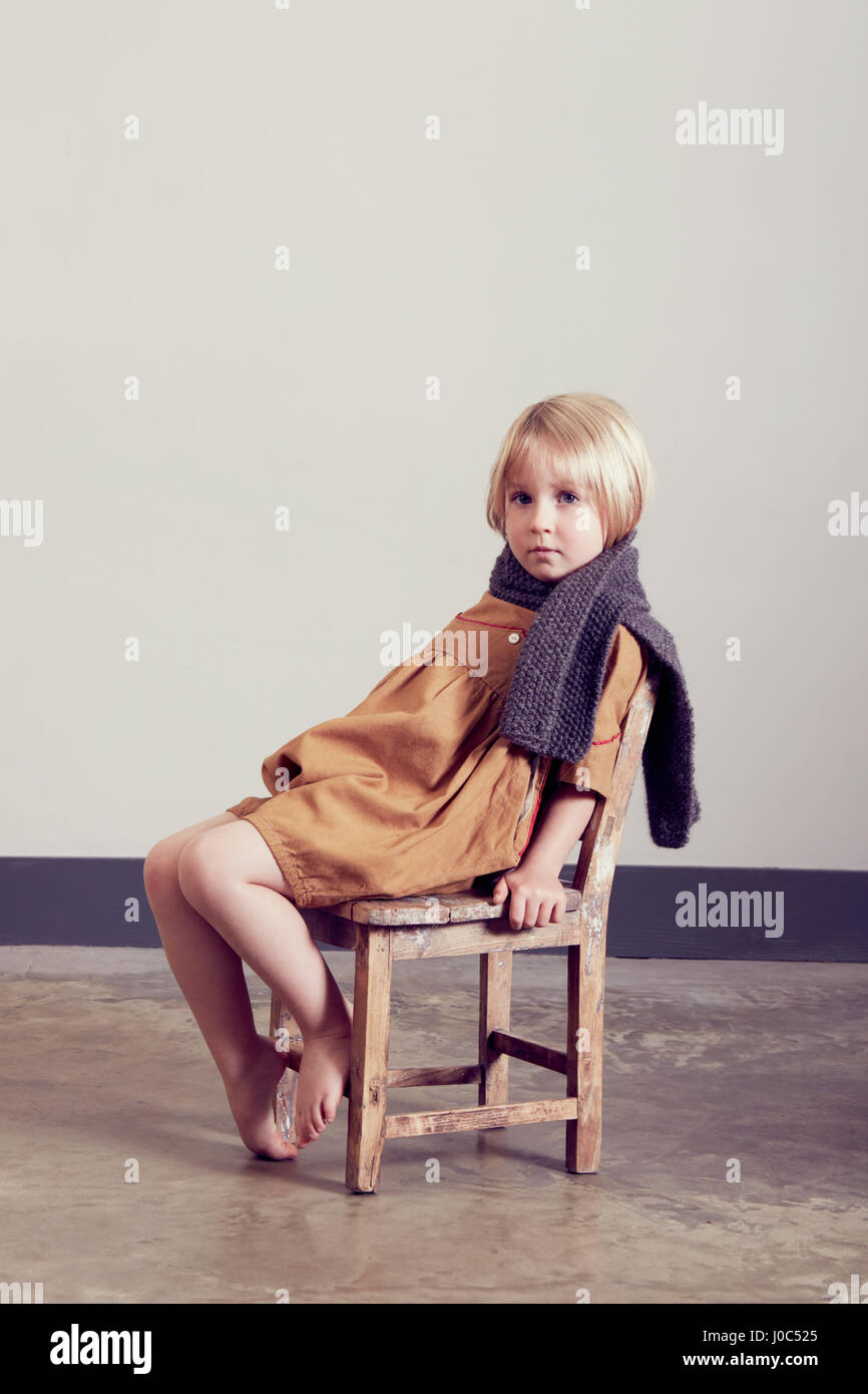 Portrait of sullen girl sitting on old wooden chair Stock Photo - Alamy