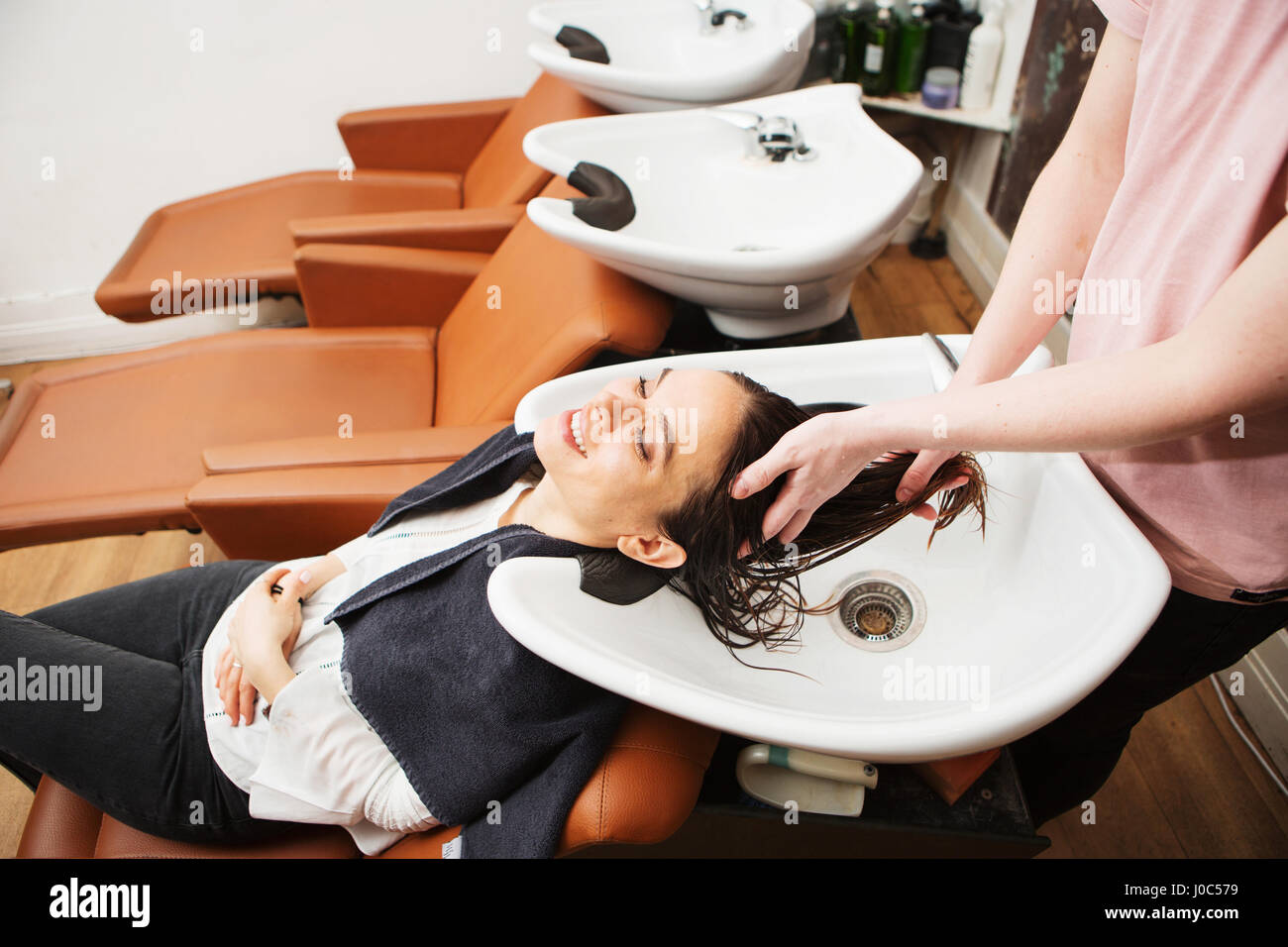 Female customer having hair washed in salon sink Stock Photo - Alamy