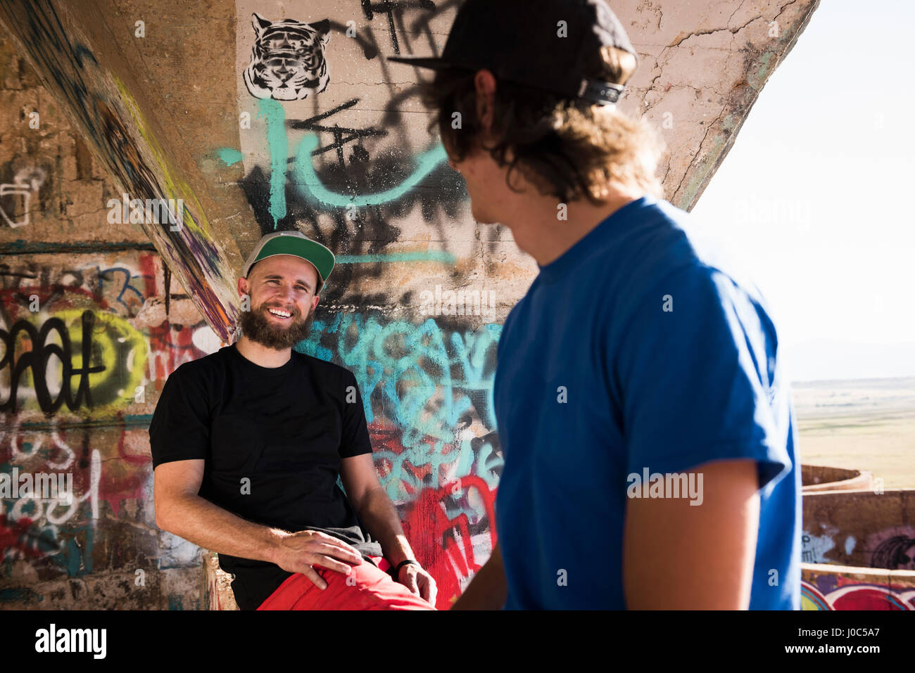 Two young men chatting in mine ruins Stock Photo - Alamy