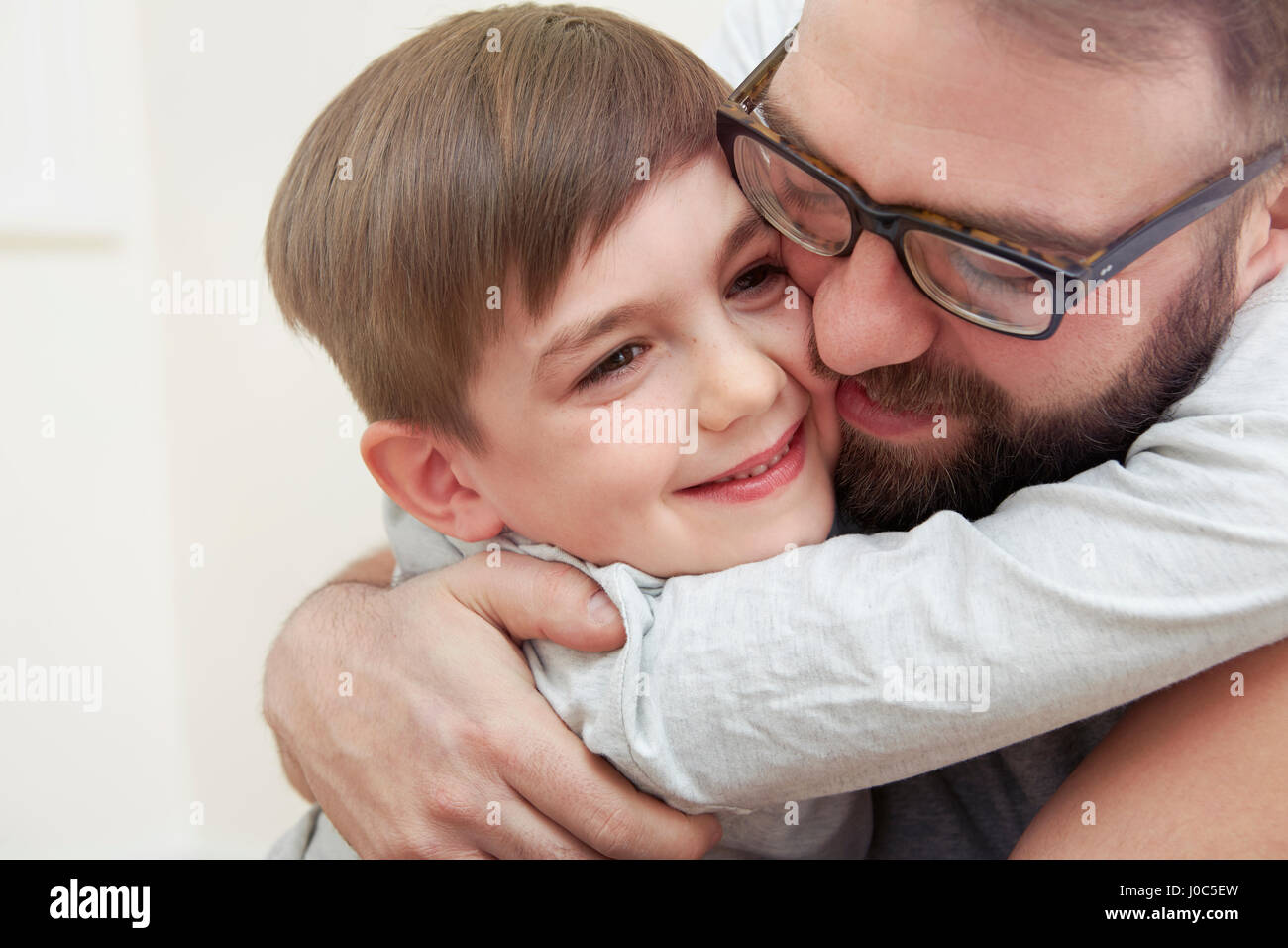 Mid adult man and son hugging each other Stock Photo - Alamy