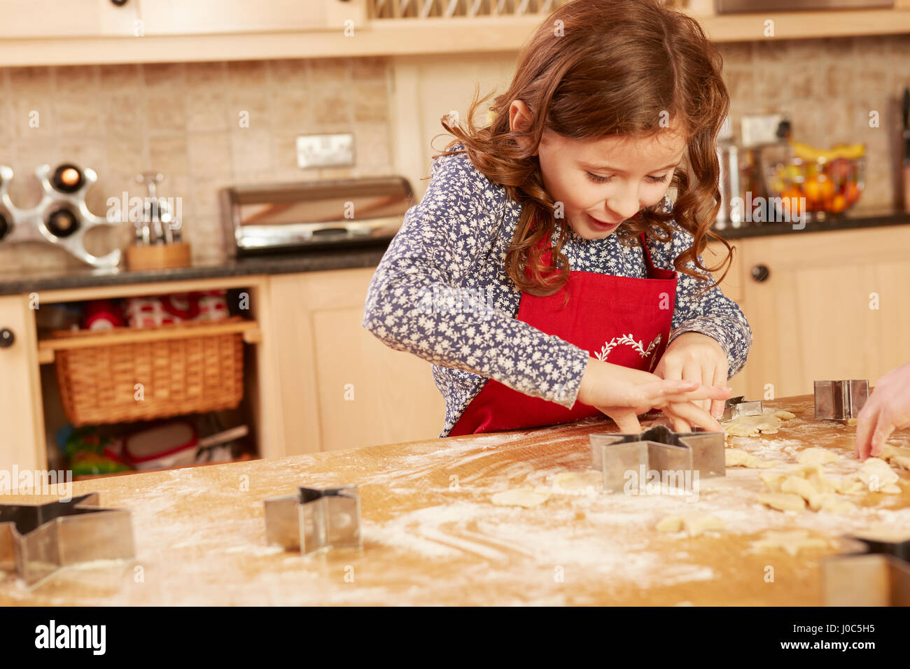 Girl baking star shape pastry at kitchen table Stock Photo - Alamy