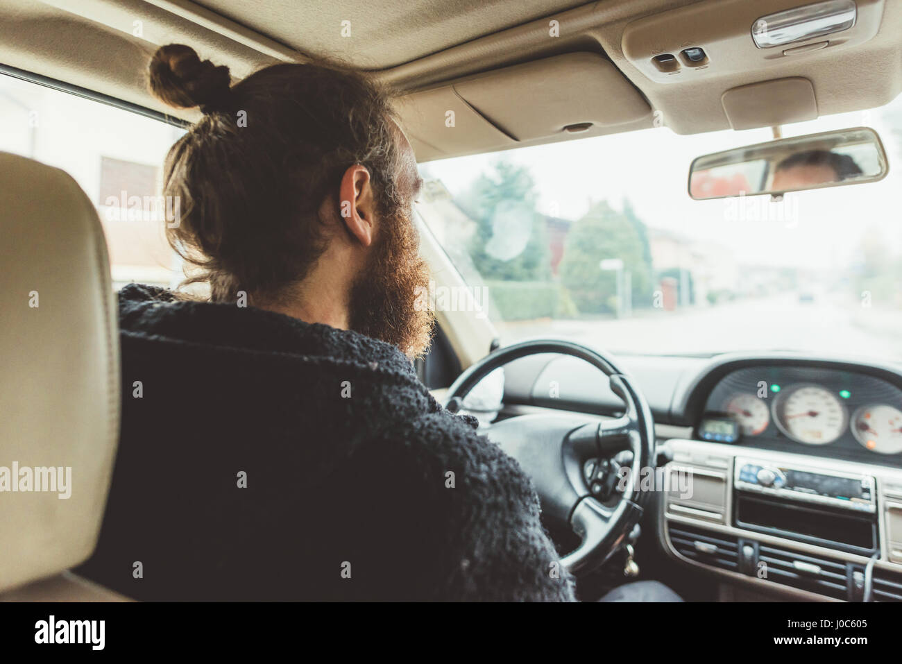 Over shoulder view of bearded man driving a car Stock Photo - Alamy
