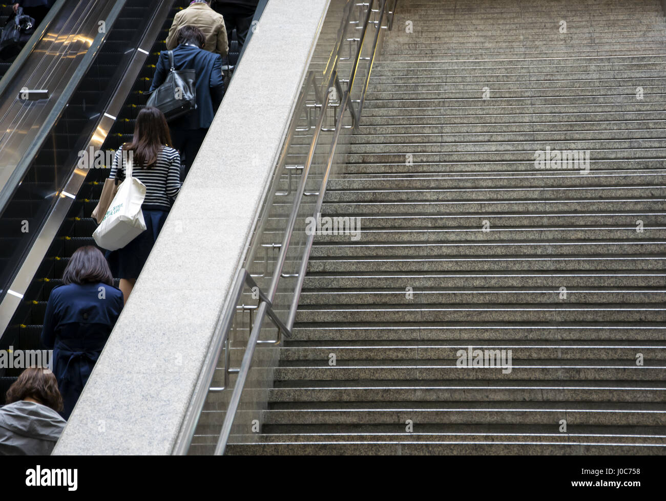 Japanese workers go up the stairs during rush hour. Business concept of ...