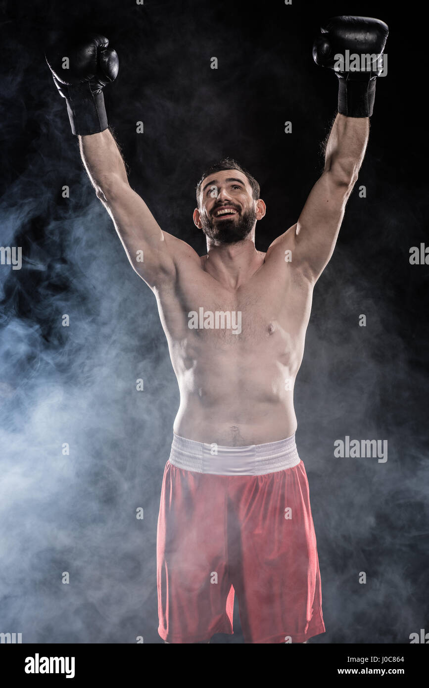 Happy young boxer celebrating his victory raising hands in gloves on ...