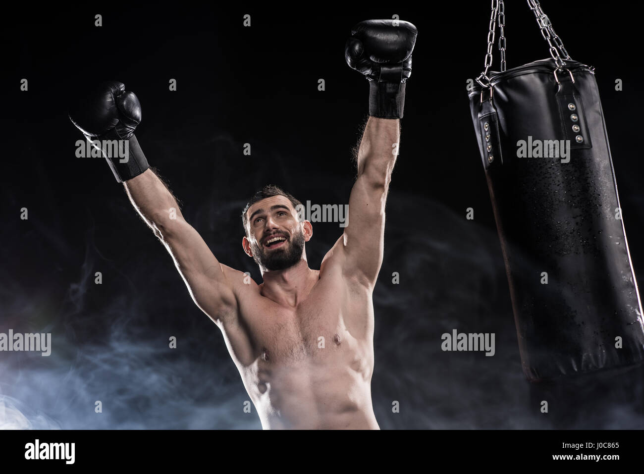 Happy young boxer celebrating his victory raising hands in gloves on ...